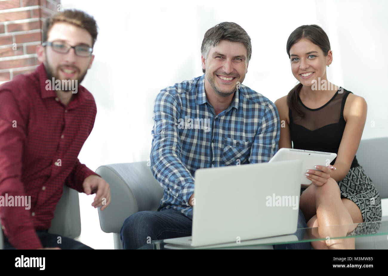 Group of young colleagues using laptop at office Stock Photo - Alamy