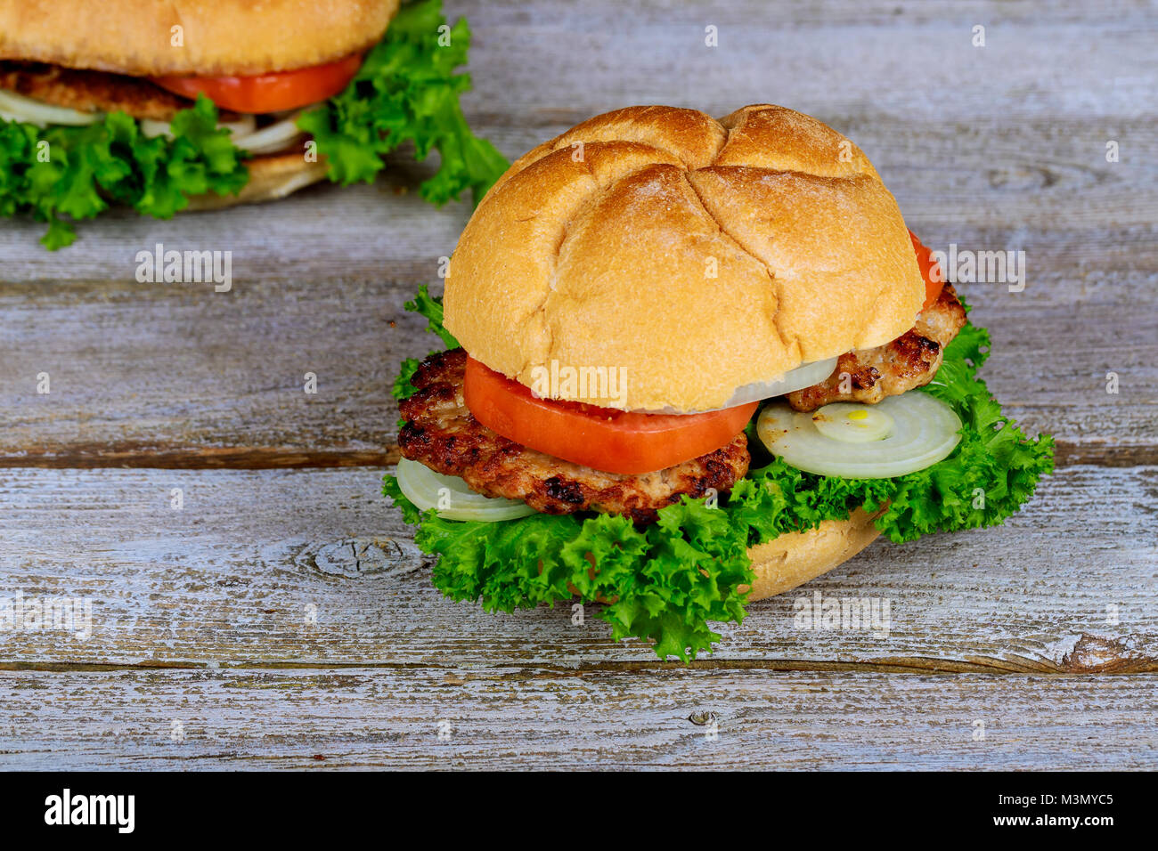 Two homemade grilled hamburgers with beef, onion, tomato, lettuce and ...