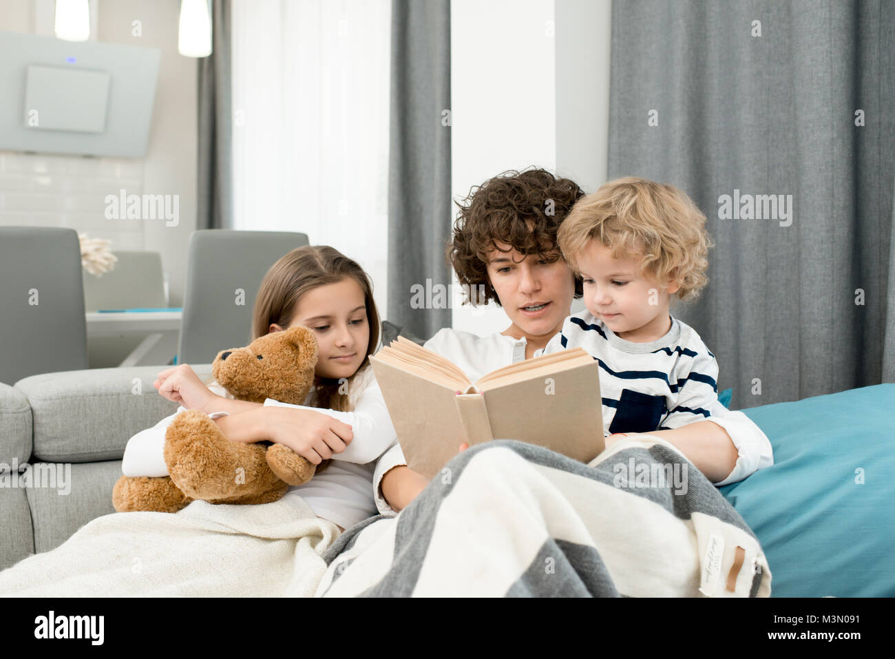 Mother Reading Book to Kids Stock Photo - Alamy