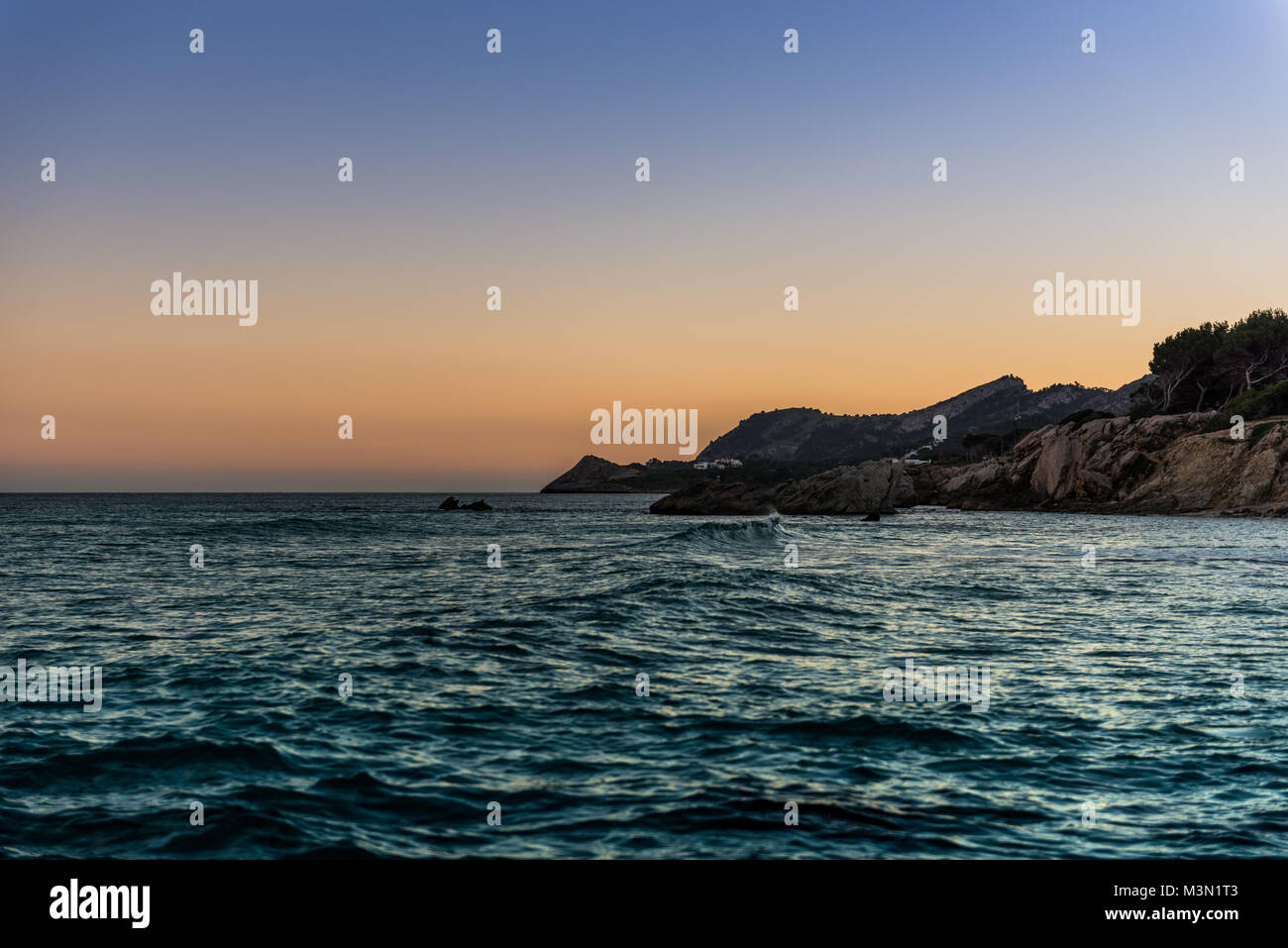 View of the shore of the coast of Cala Moll in the mediterranean sea of ...