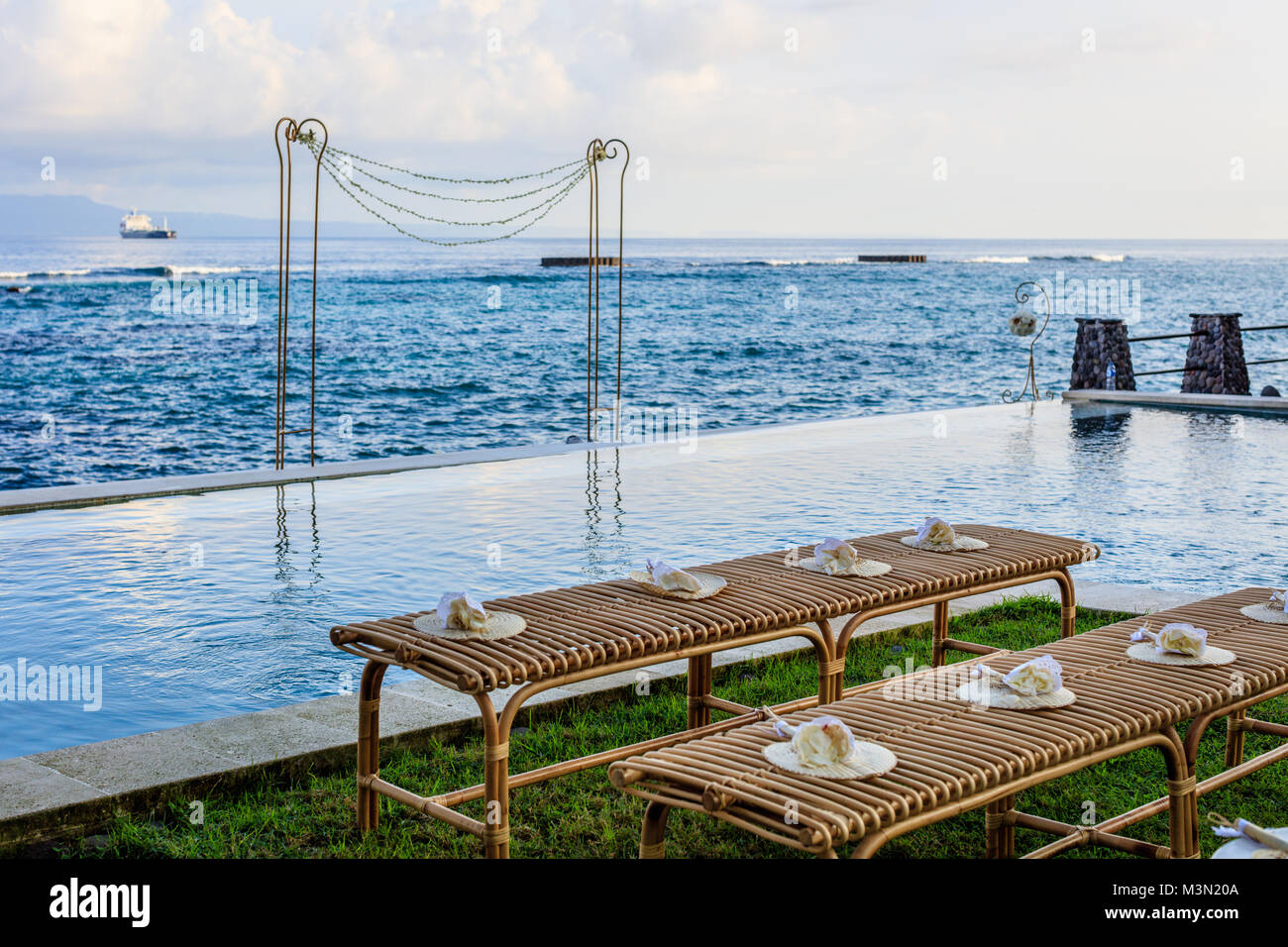 Wedding ceremony setup near the ocean at sunset - rattan benches for ...