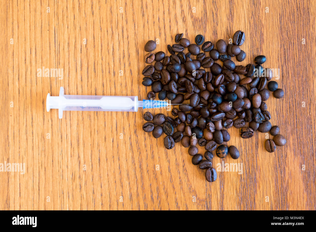 Coffee dependence. Syringe and grains of coffee Stock Photo - Alamy