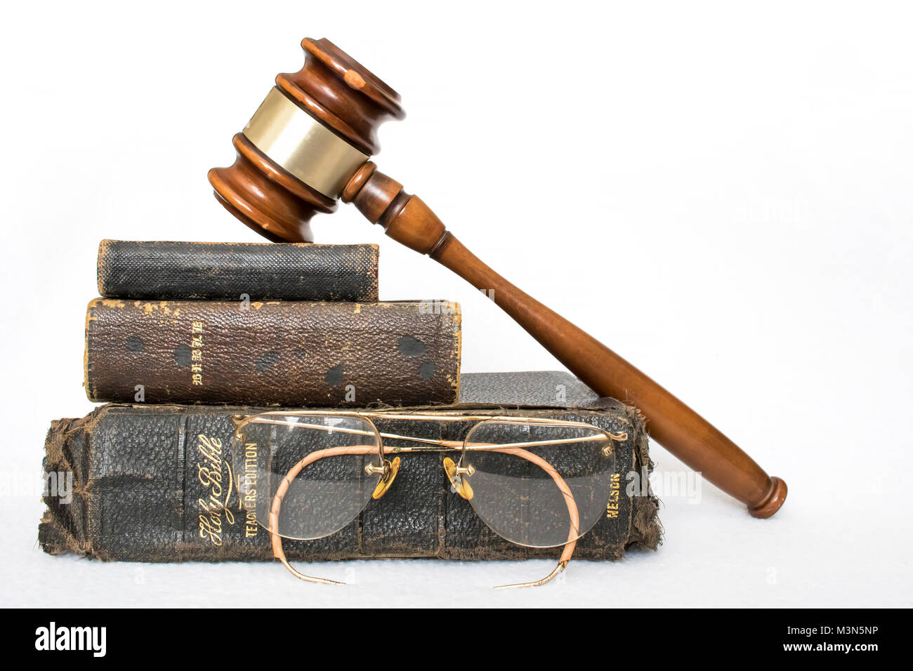 Stack of Antique Worn Leather Bibles with Gavel and Rimless Glasses on ...
