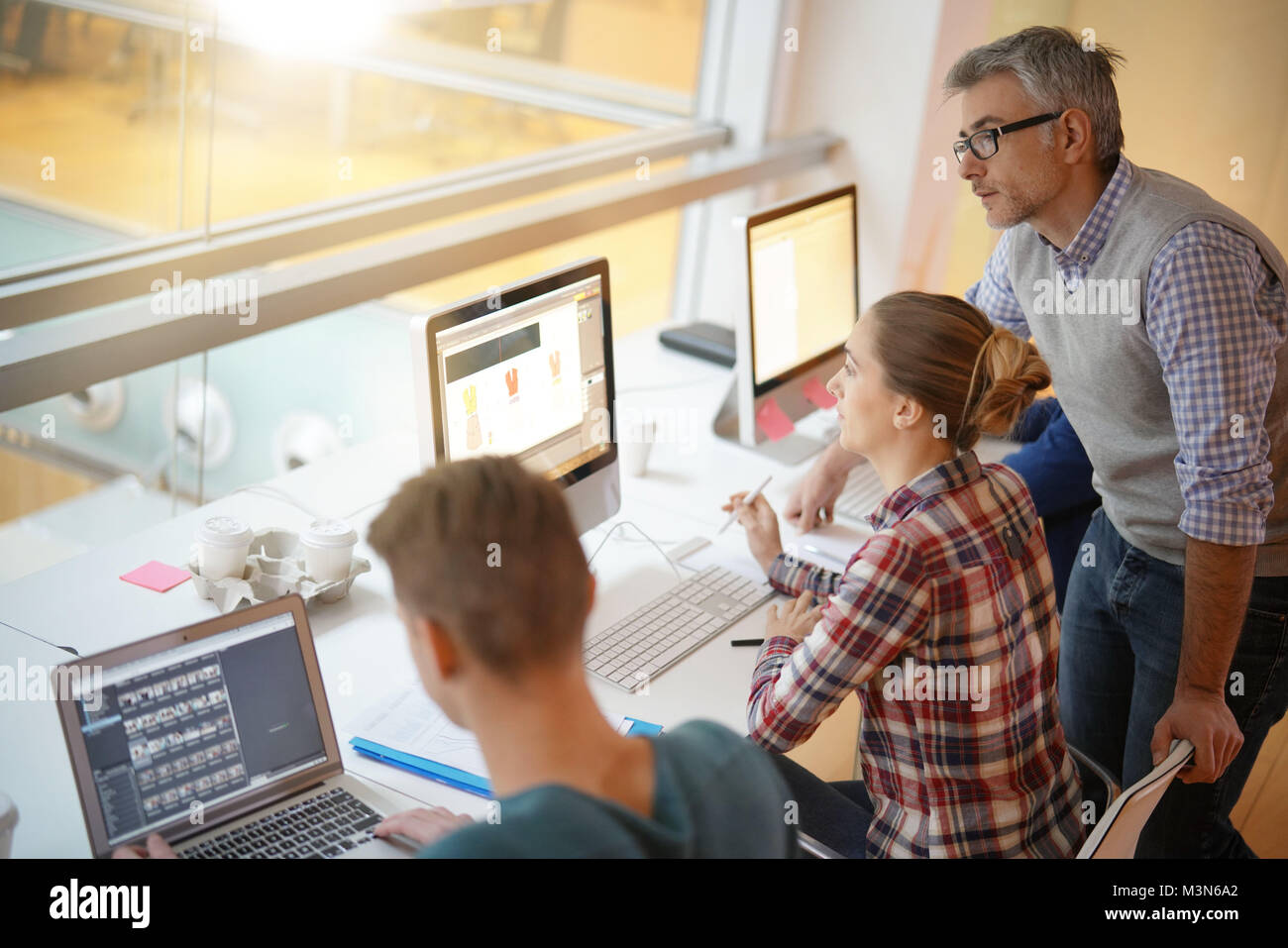 Teacher with students in computing class Stock Photo - Alamy