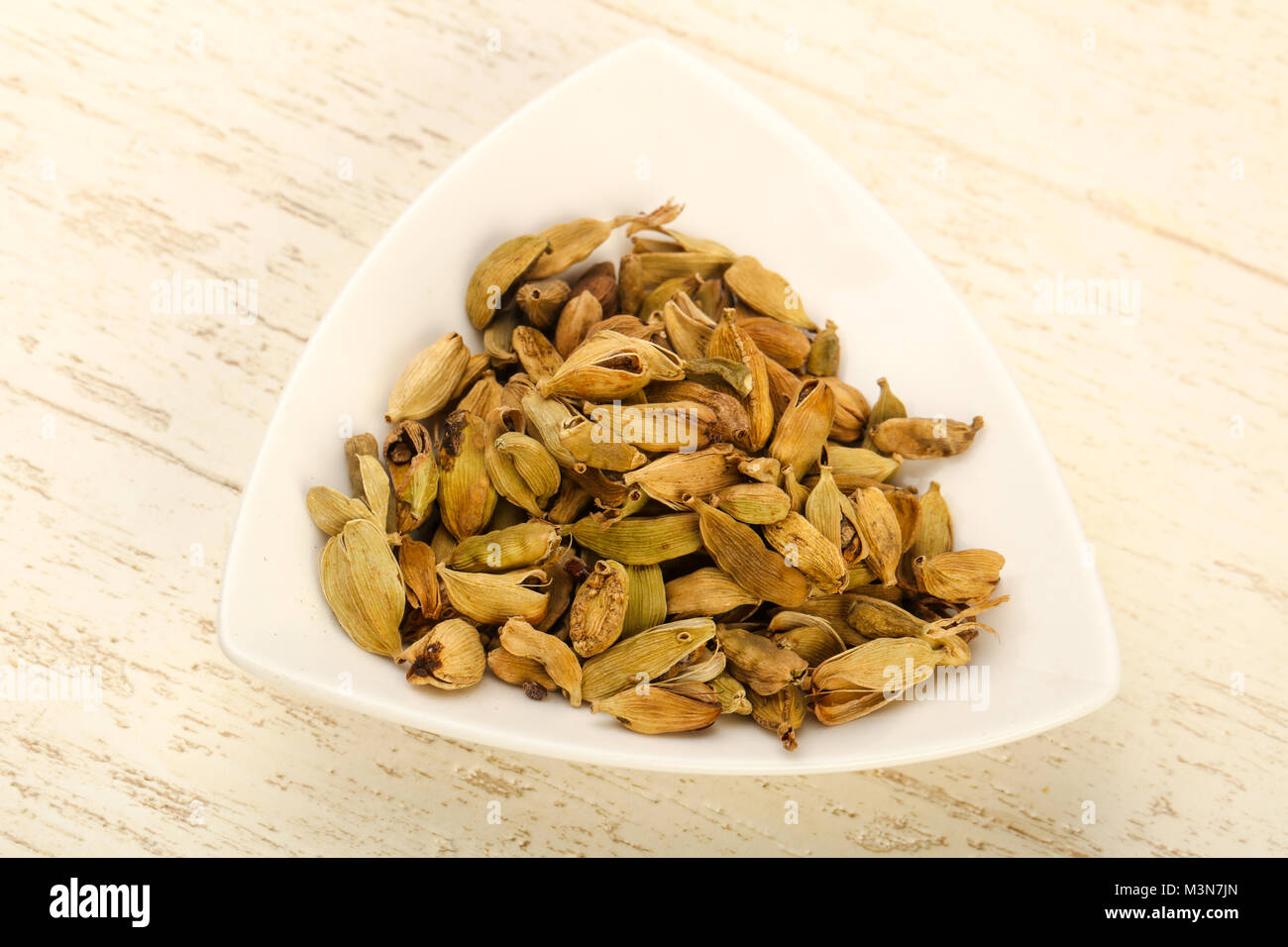 Dry cardamom seeds heap in the bowl Stock Photo - Alamy