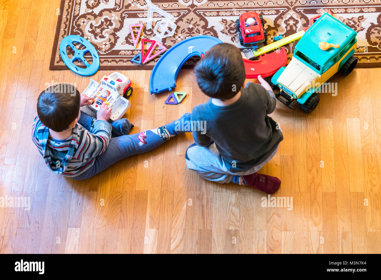 Two little brothers play in the game room with cars. Top view Stock ...