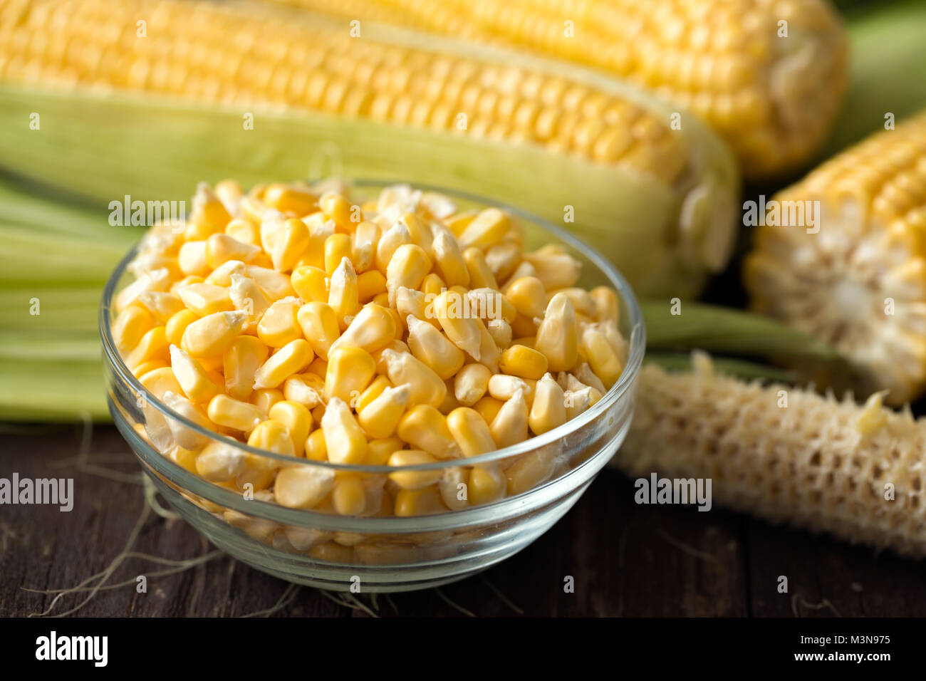 Sweet corn grain in bowl on rustic wooden table Stock Photo - Alamy