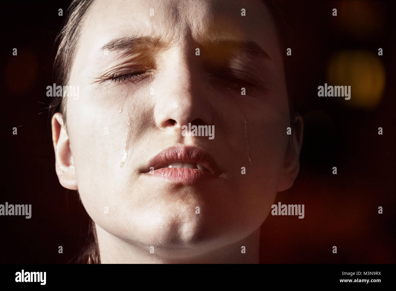 sad woman crying on dark background, closeup portrait Stock Photo - Alamy