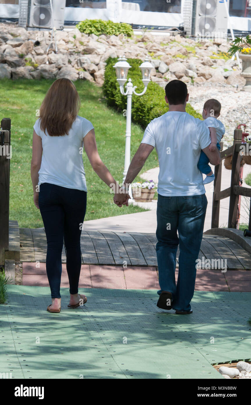 Married Couple Holding Hands and Carrying Child Stock Photo - Alamy