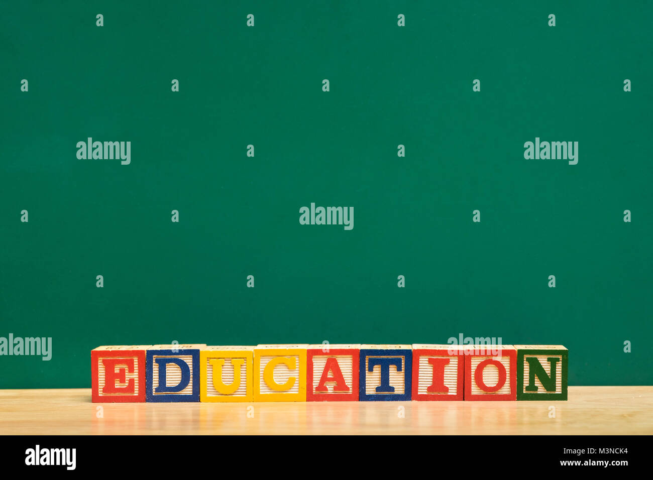 Colorful Education word wood block on wood table with green blackboard ...