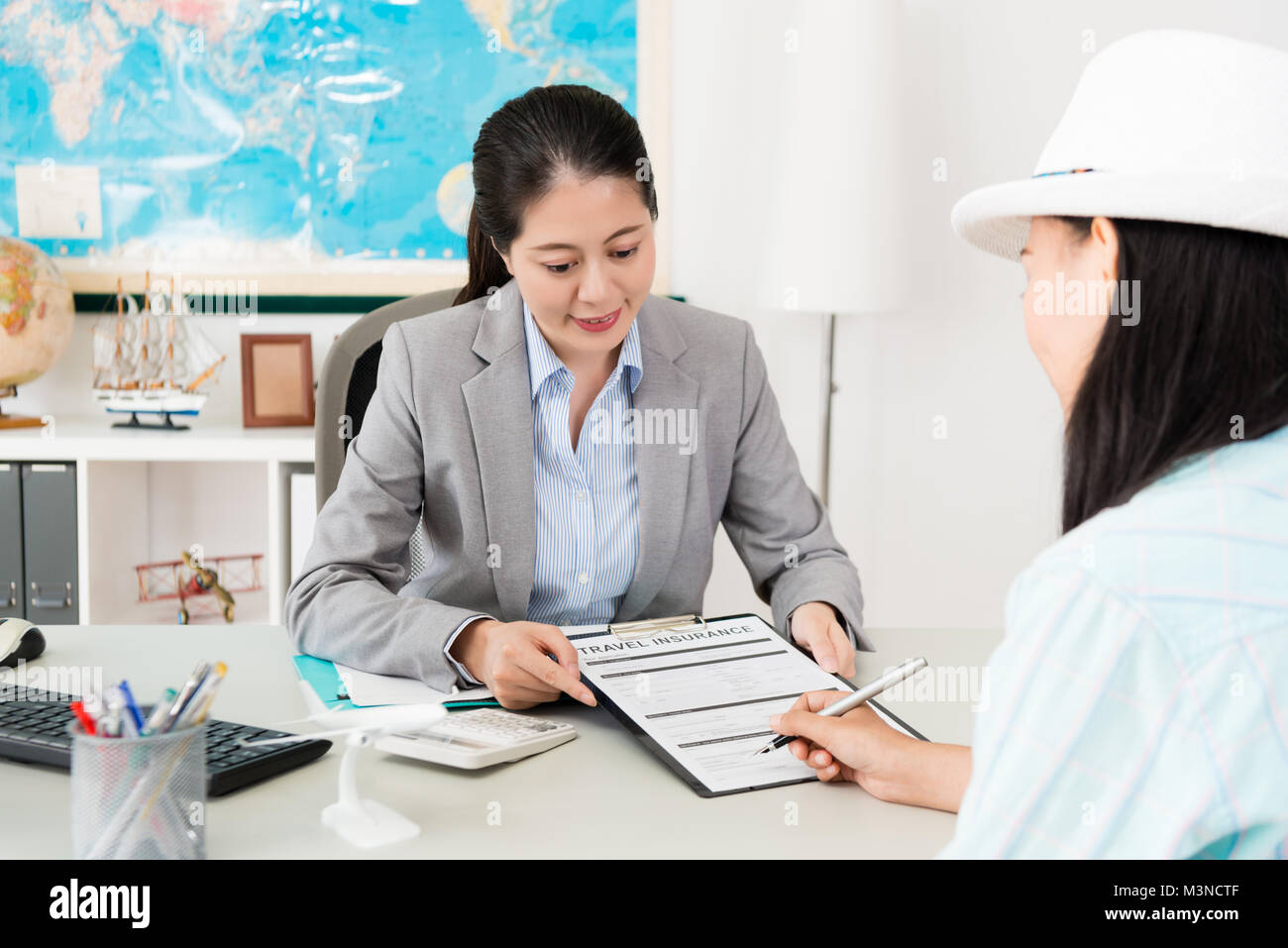 pretty beauty girl signing travel insurance document in order to ...