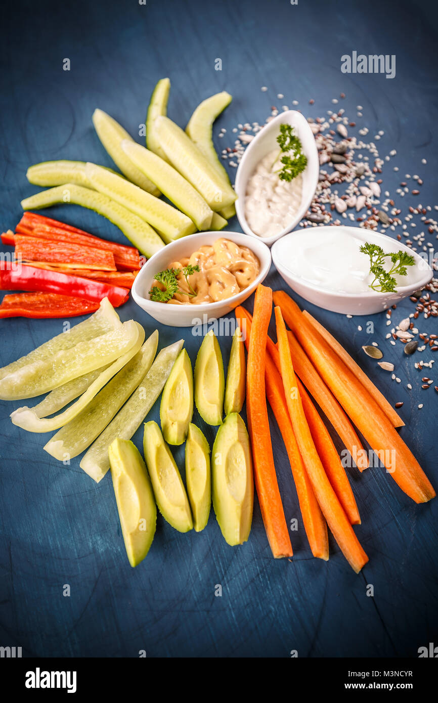 Assorted raw vegetables sticks on blue background Stock Photo - Alamy
