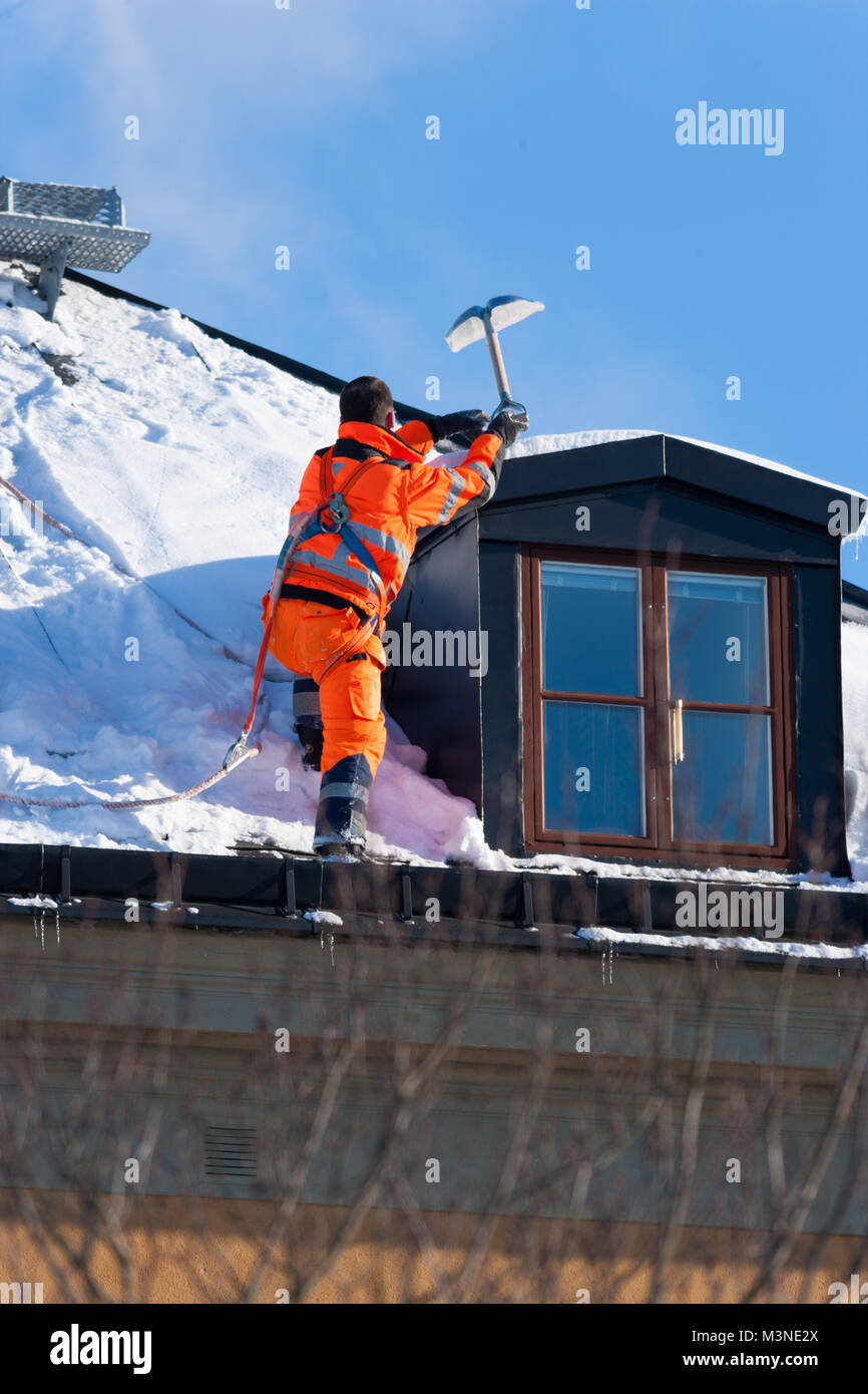 Sweeping snow off a roof in winter Stock Photo - Alamy