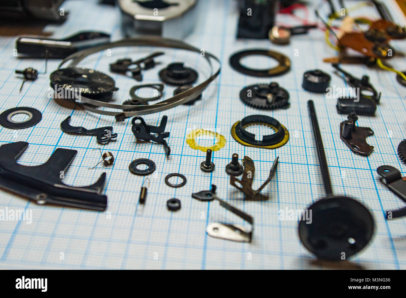 parts are completely disassembled old retro film SLR camera on graph ...