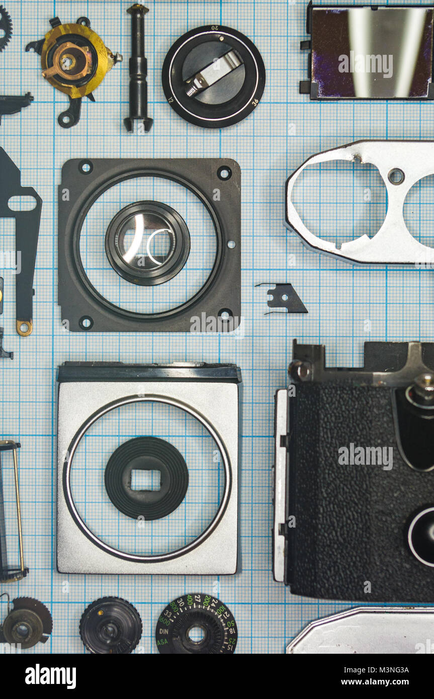 parts are completely disassembled old retro film SLR camera on graph ...