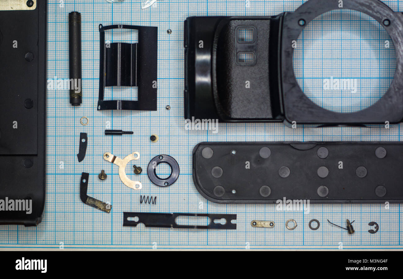 parts are completely disassembled old retro film SLR camera on graph ...