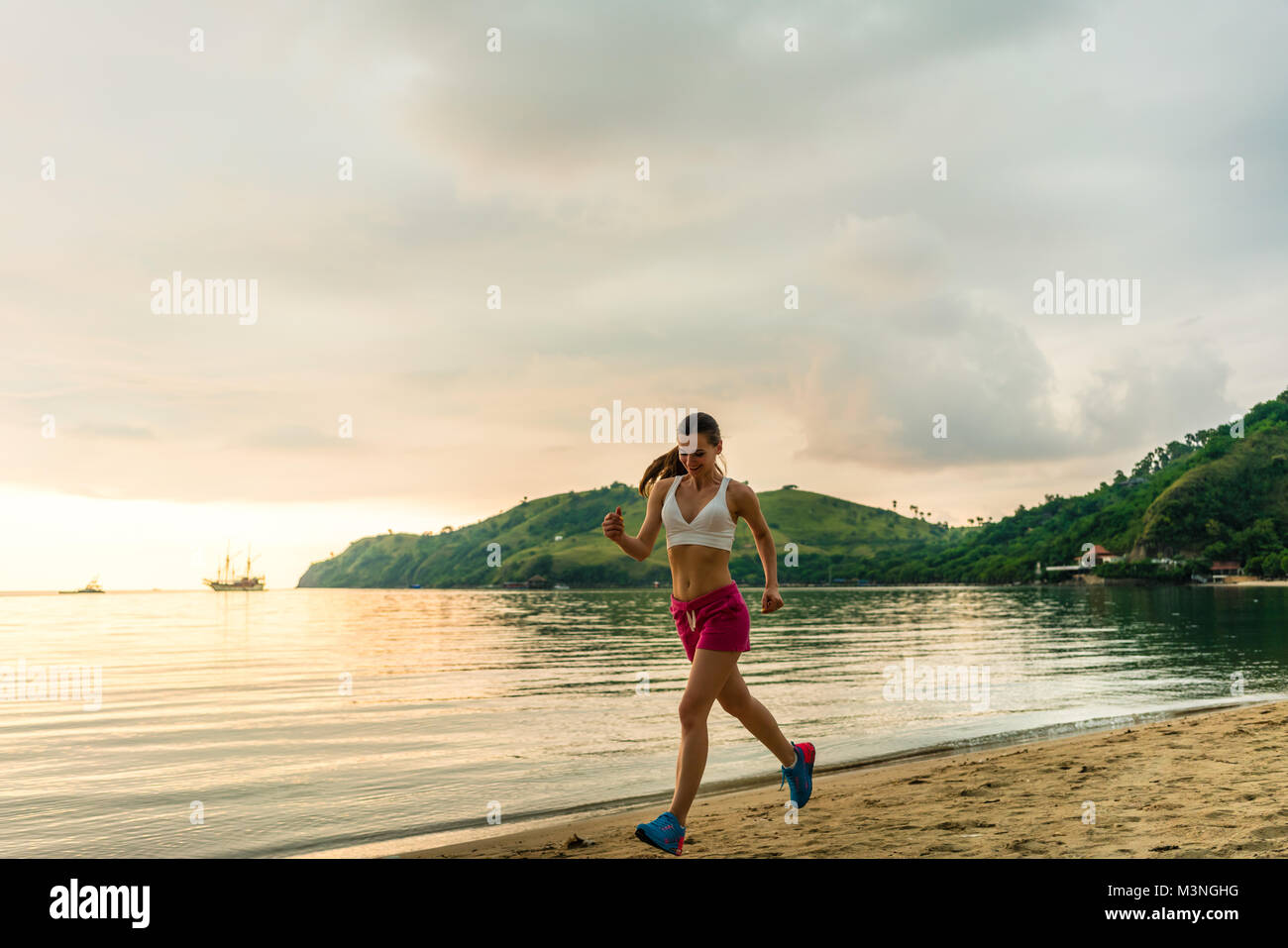 Fit young woman with a healthy lifestyle smiling while running on the ...