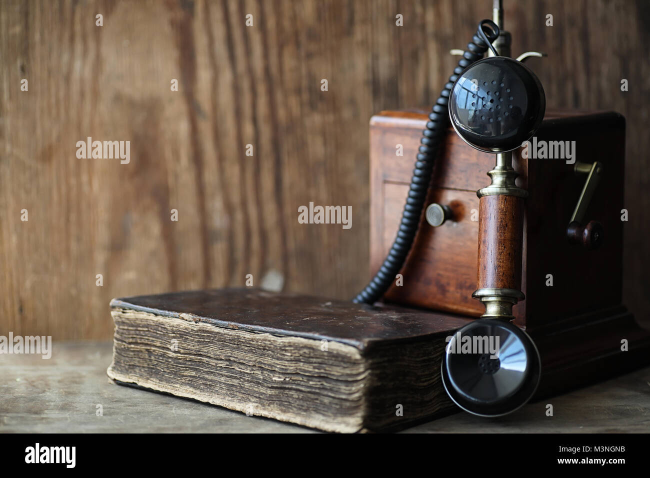 Old telephone and retro book on a wood Stock Photo - Alamy