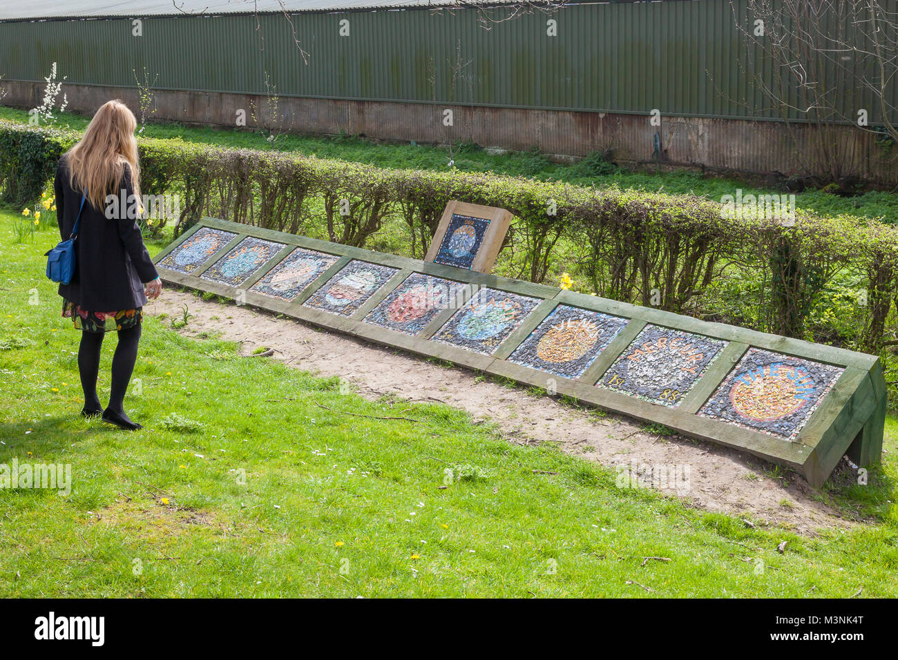 A woman views the Mosaic art work of the Solar System designed by ...