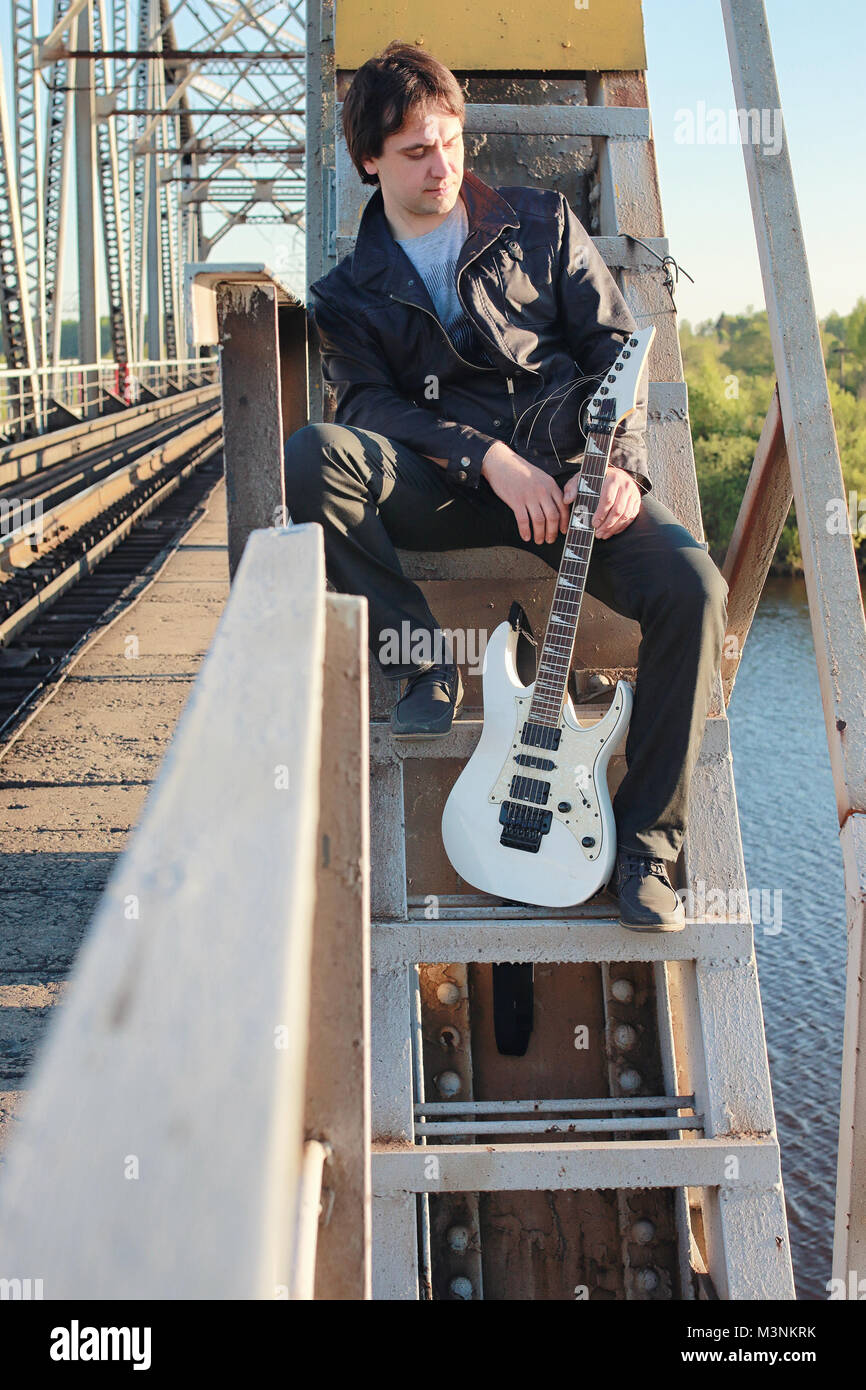 Man with an electric guitar in the industrial landscape outdoors Stock ...