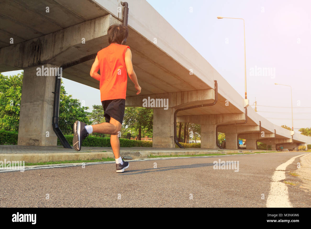 Running on the road with sunlight / The man runner Stock Photo - Alamy