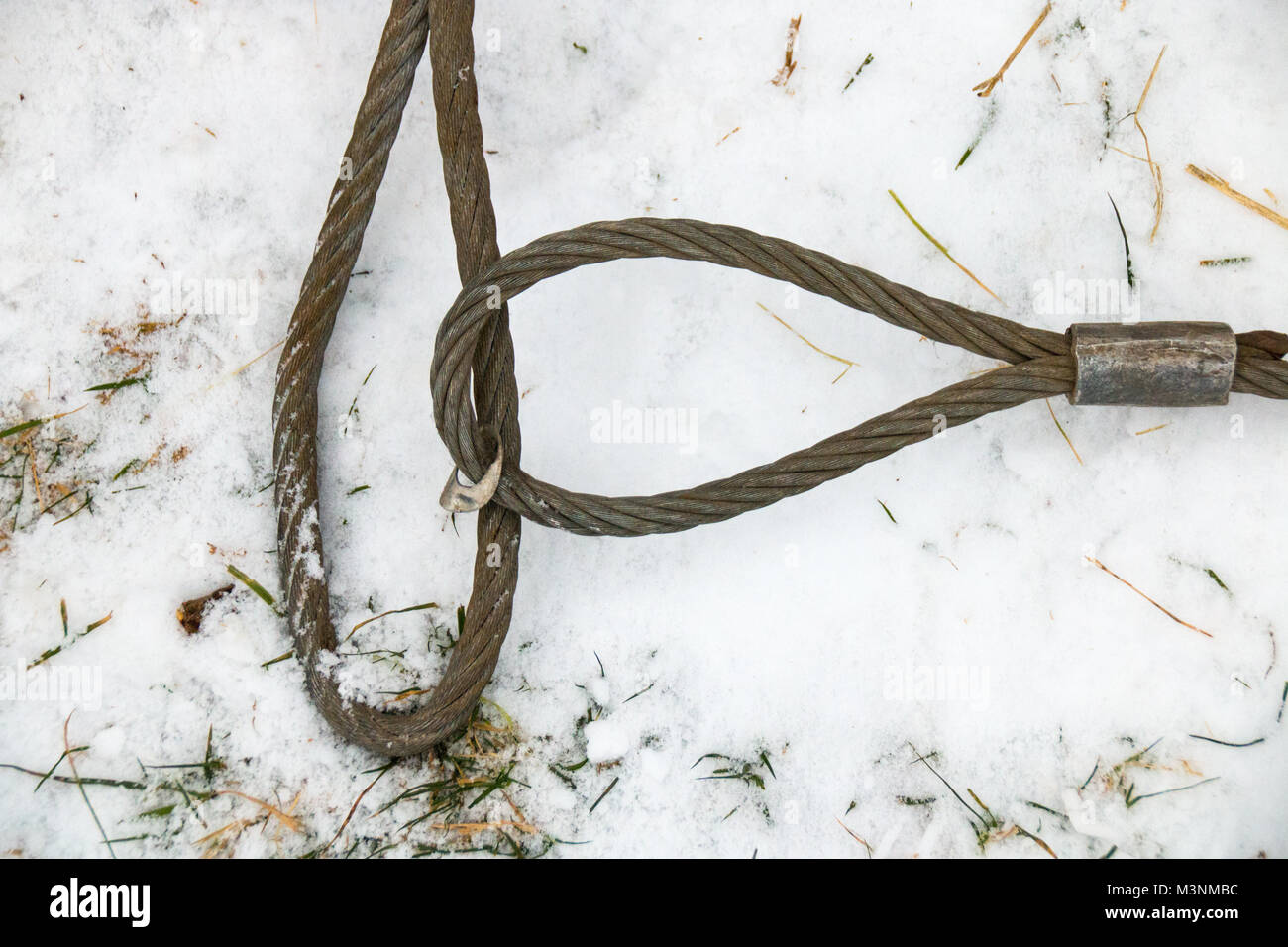 Two steel loops of a rope in the snow Stock Photo - Alamy