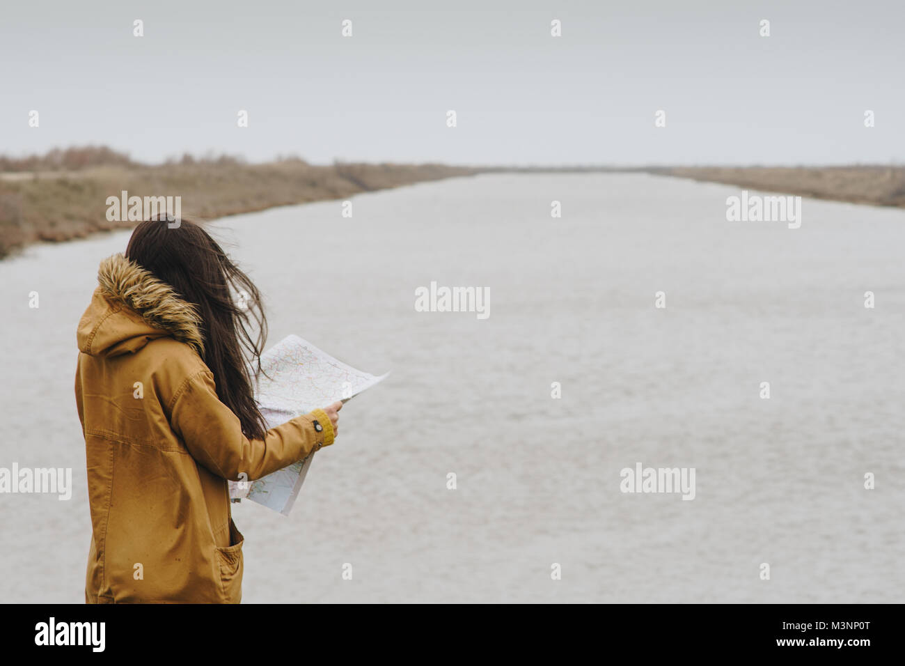 Woman reading a map next to a river, Greece Stock Photo - Alamy