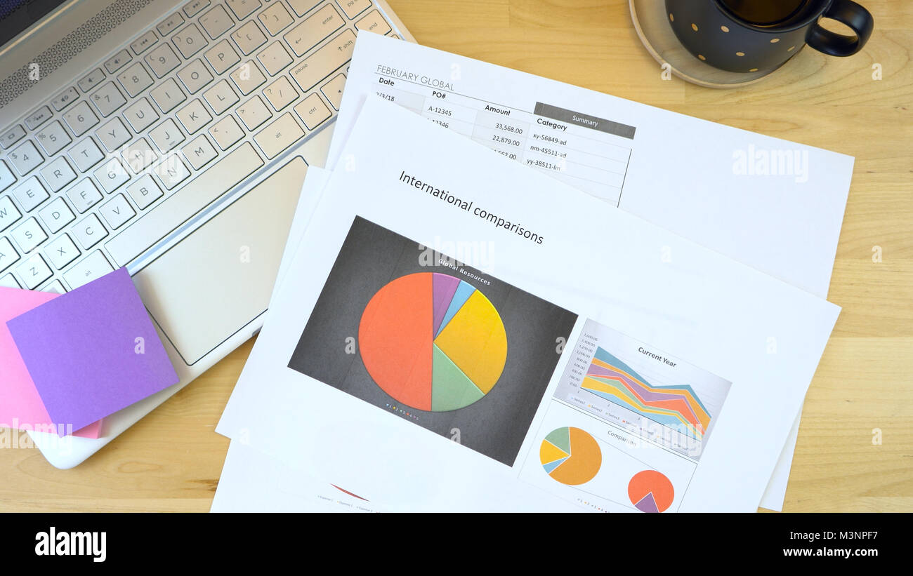 Modern office desk overhead with laptop pc and graphs paperwork ...