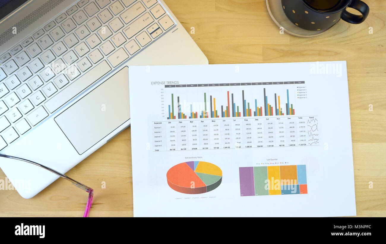 Modern office desk overhead with laptop pc and graphs paperwork ...