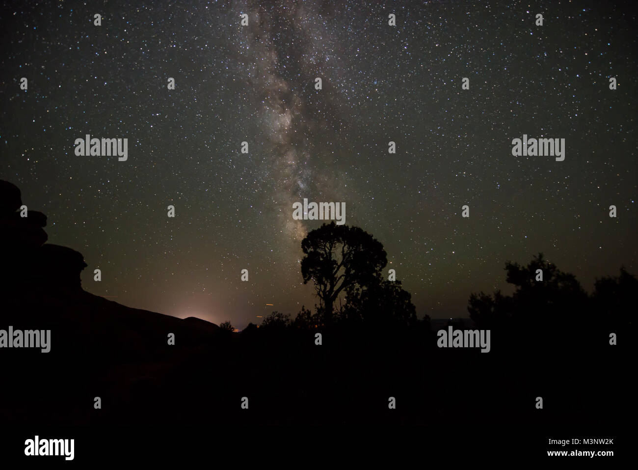 Milky Way from Garden of Eden Viewpoint. The lights of Moab, Utah, are ...