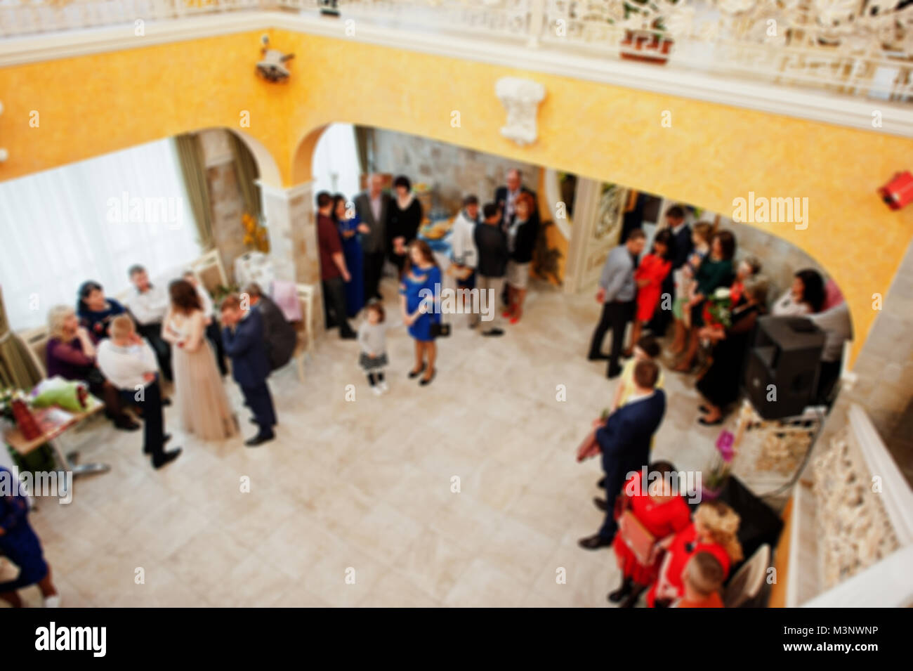 Guests standing in the restaurant hall waiting for the wedding couple ...