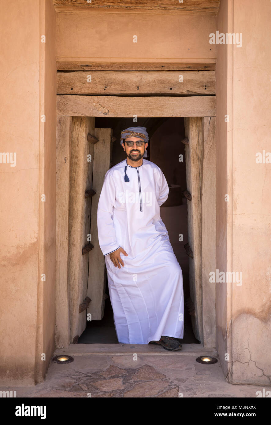 arab man in traditional omani outfit coming out of a door Stock Photo ...