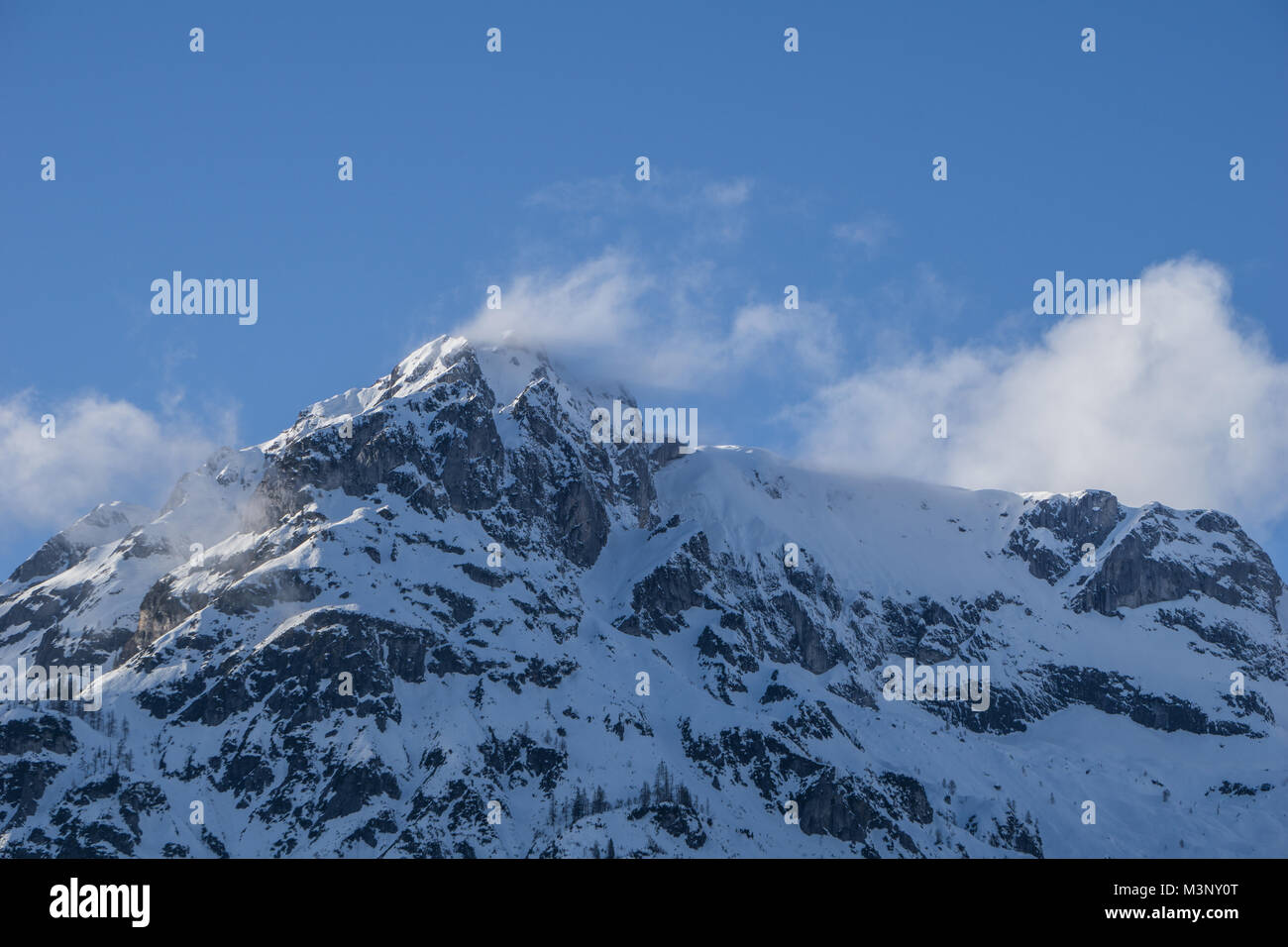 Wind blowing snow off the top of a rugged mountain in Austria Stock ...