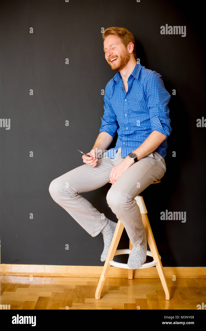 Portrait of redhair man with mobile phone by wall Stock Photo - Alamy