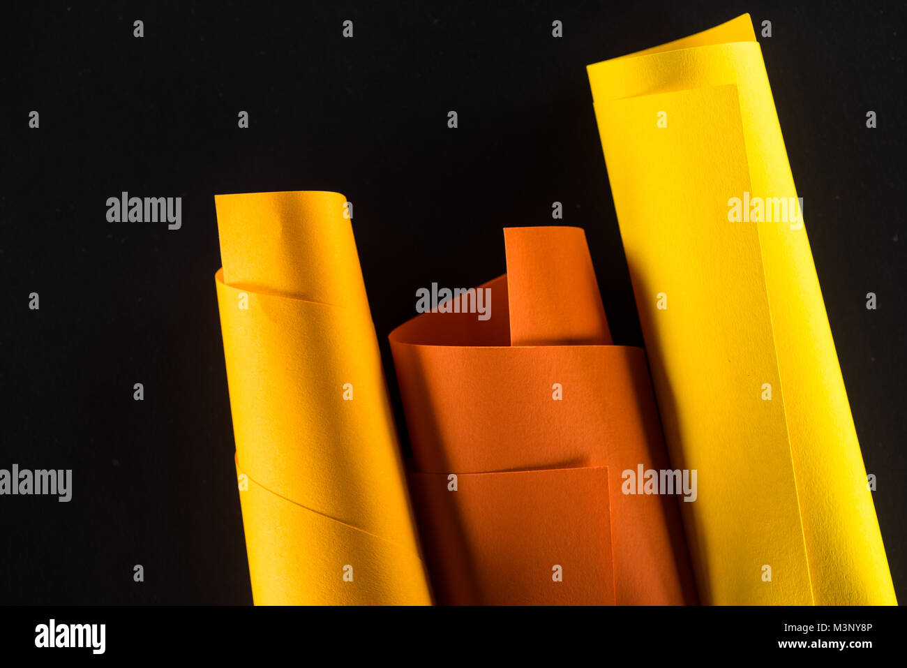 rolled color papers isolated on black Stock Photo - Alamy