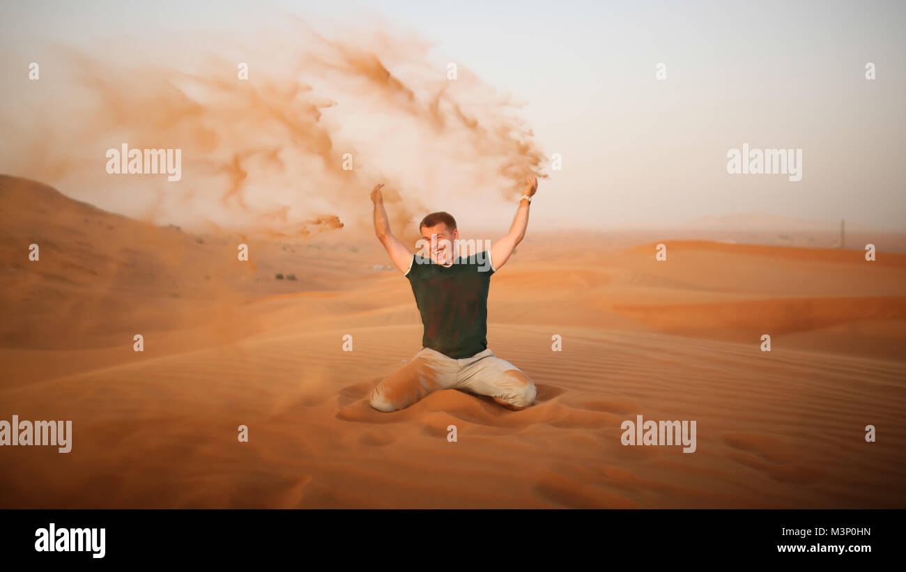 The guy throws sand over himself in the desert. The desert is next to ...