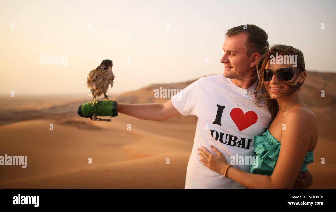 Girl and the guy keep on hand eagle. Desert in Abu Dhabi, United Arab ...