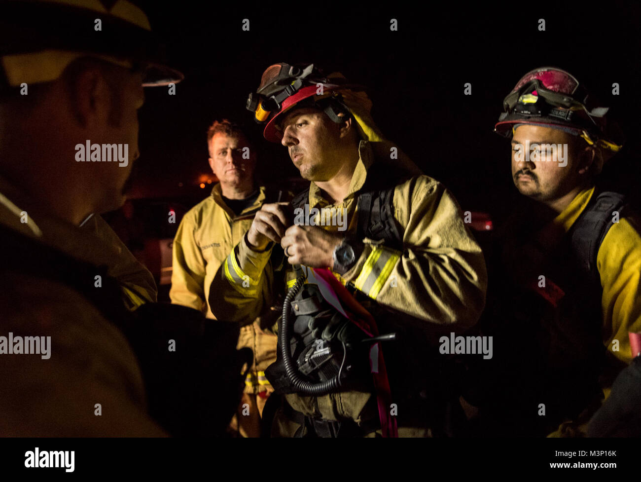 Firefighters assemble before performing a controlled burn to starve the ...