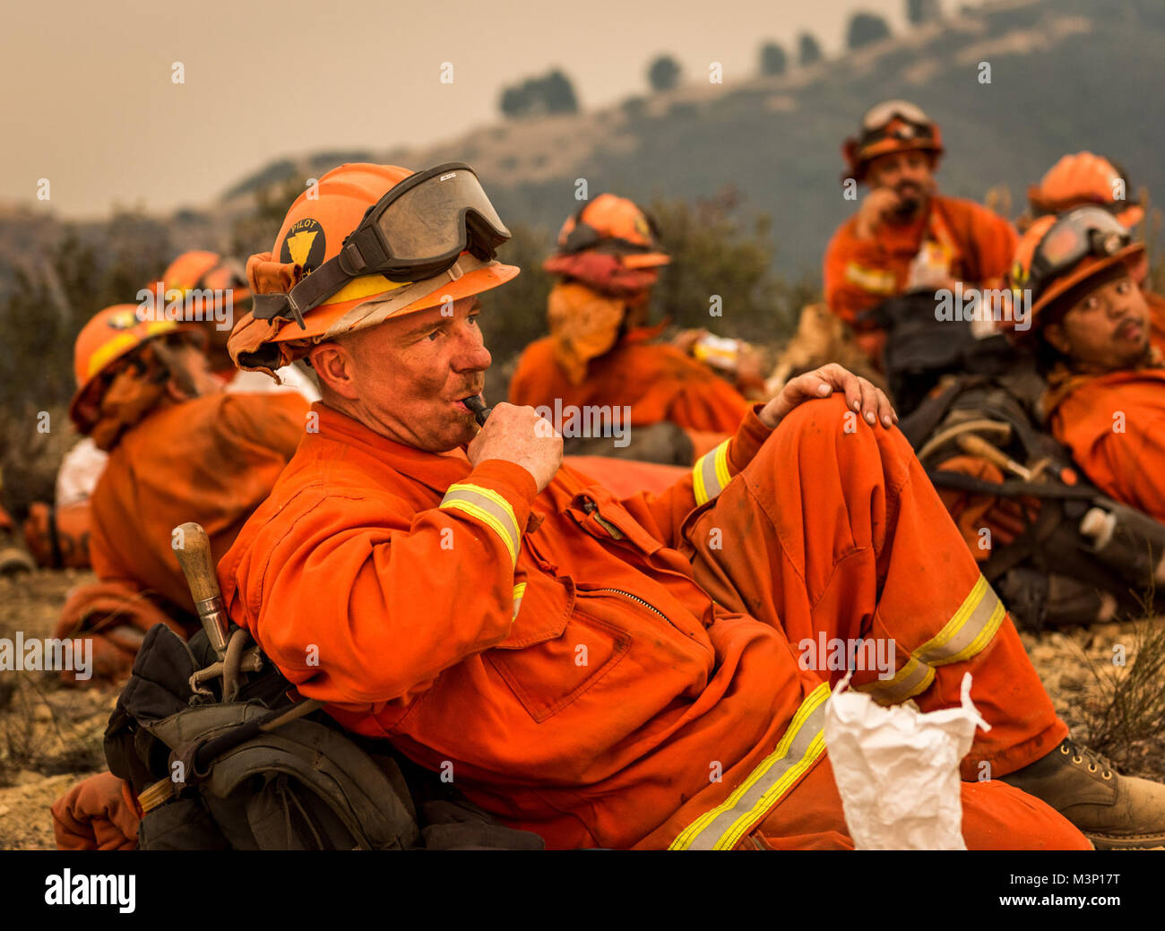 A Cal Fire crew of prison inmates rests after clearing a fire break on ...
