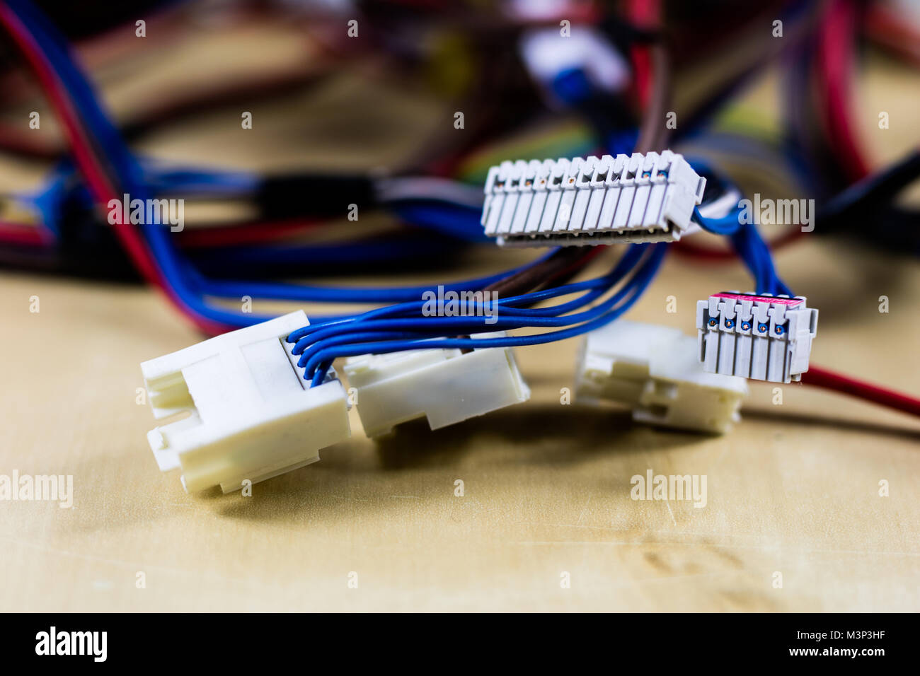 Electric cables, plugs and connectors on a wooden workshop table ...