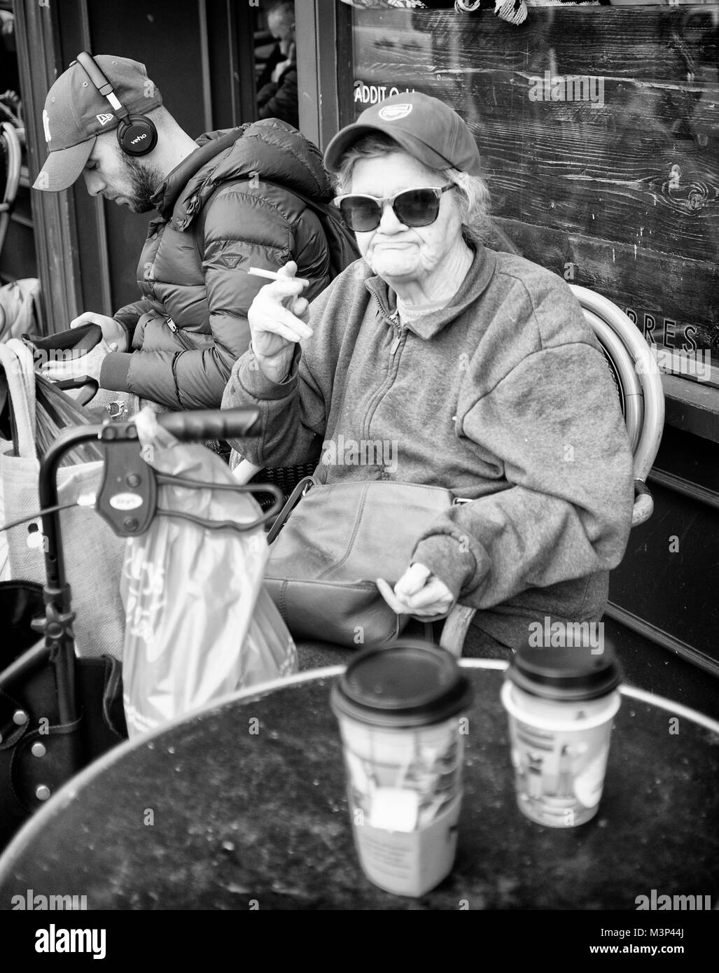 Woman smoking a cigarette outside a coffee shop in Tooting, London ...