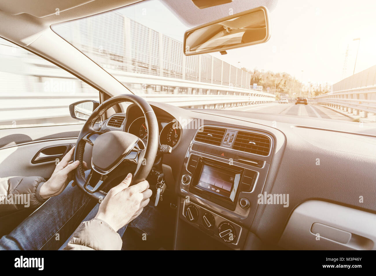 Young man driving a car with two hands. Concentrating and safe driving ...