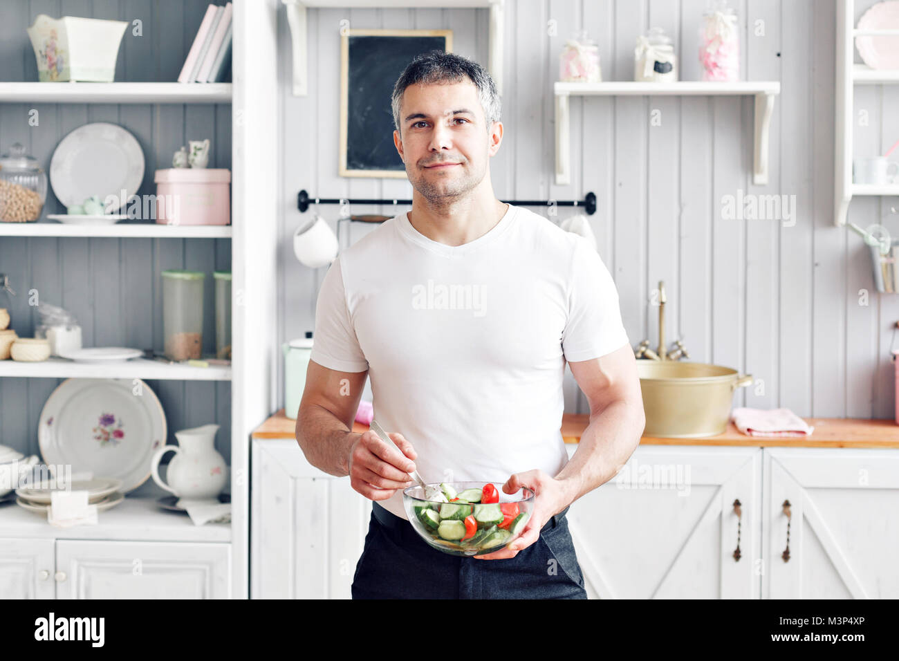 Portrait of handsome smiling man at kitchen. cooking and home concept ...