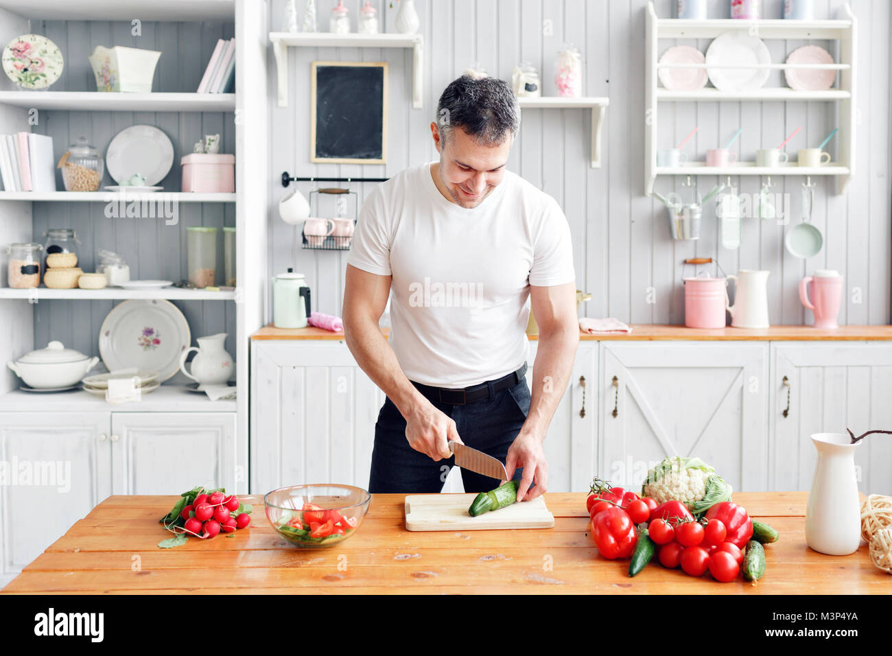 Portrait of handsome smiling man at kitchen. cooking and home concept ...