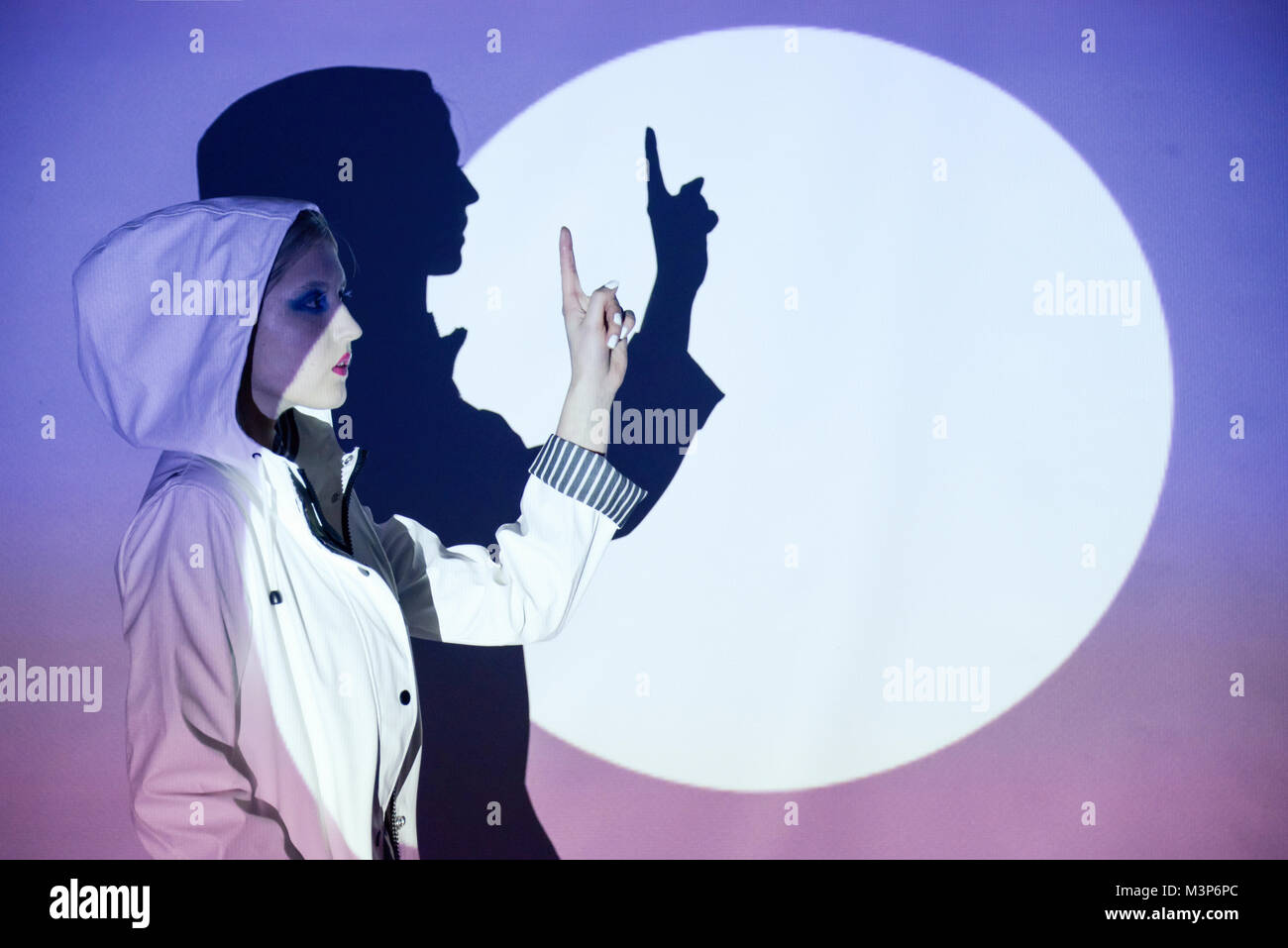 A beautiful girl with bright make up and long blond hair has light and ...