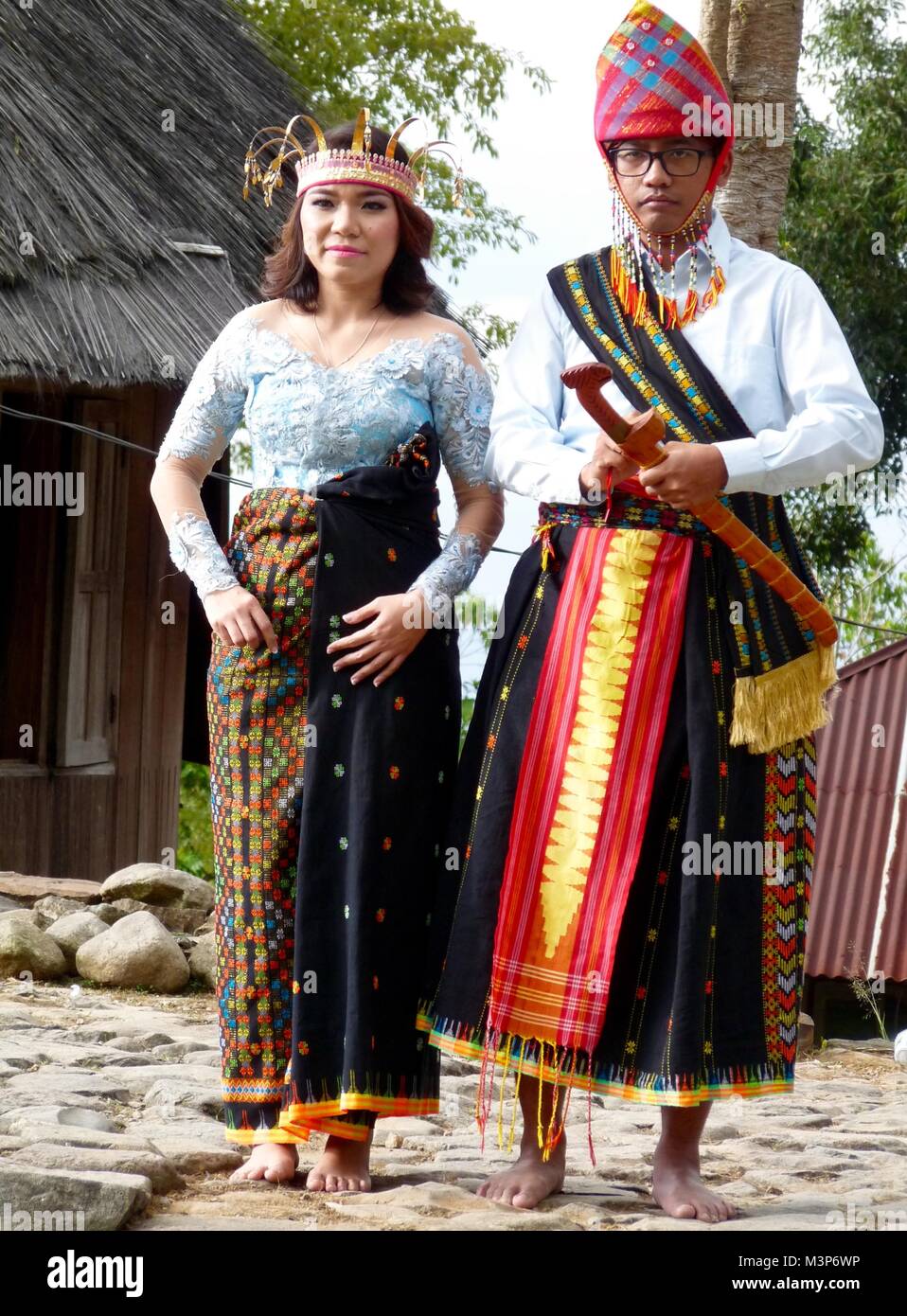 Bride and groom dressed for traditional wedding stand in front of ...