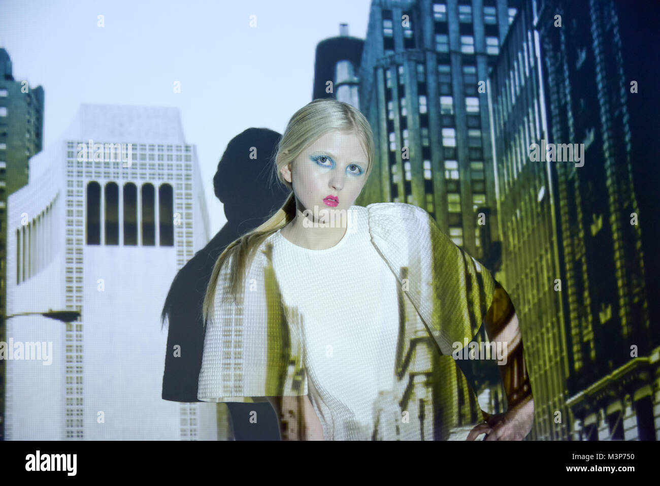 A beautiful girl with bright make up and long blond hair has light and ...