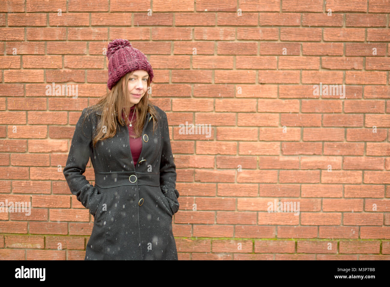 Lady keeping warm in the snow Stock Photo - Alamy