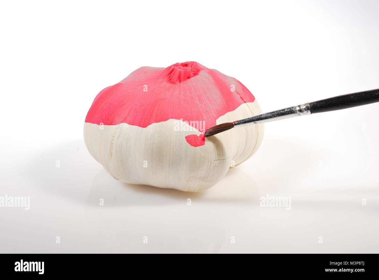 a wthite garlic painted with red color Stock Photo - Alamy