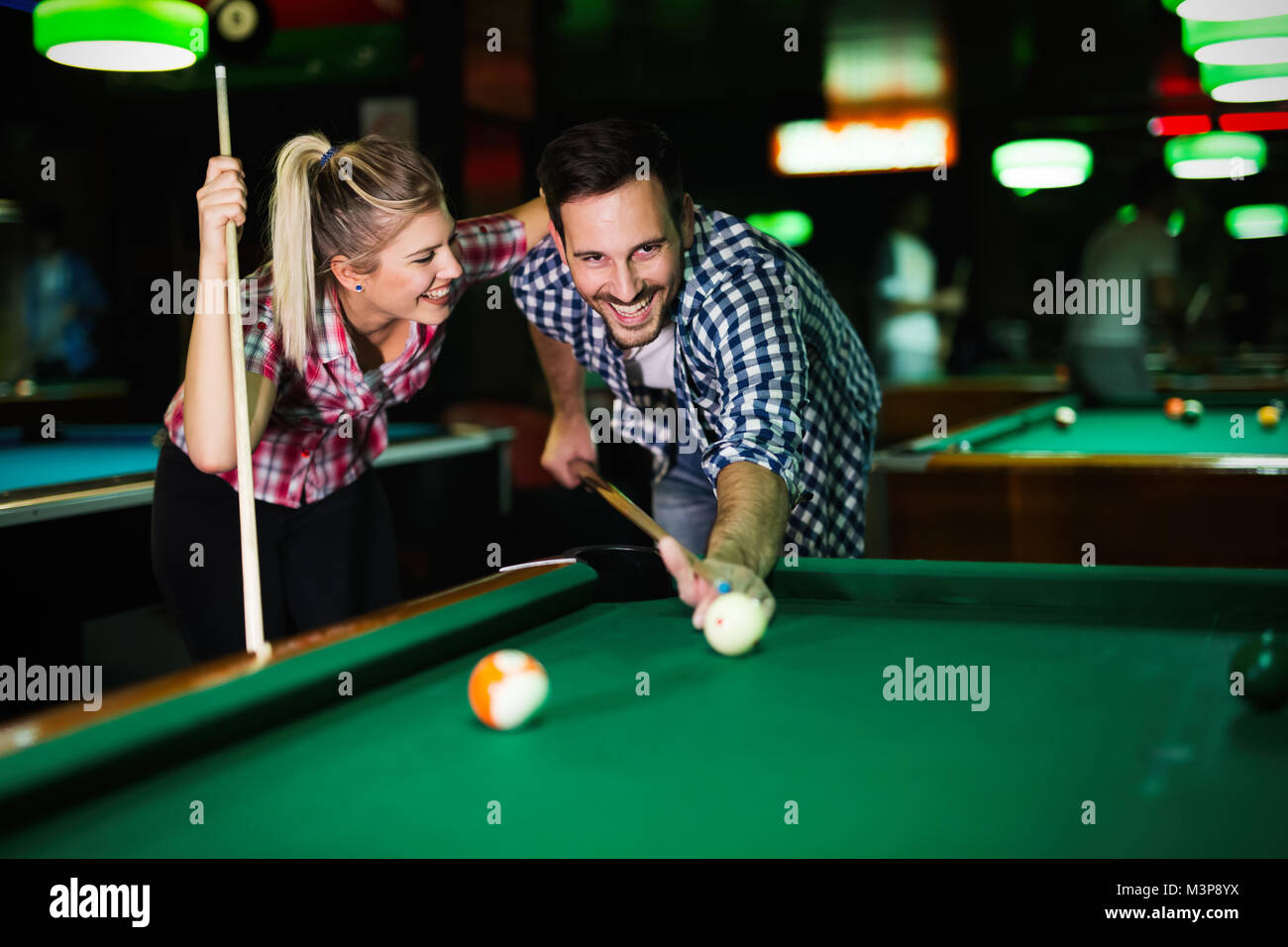Young couple playing snooker together in bar Stock Photo - Alamy